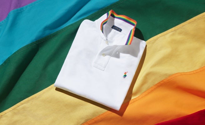 Pride Polo shirt folded on top of rainbow flag